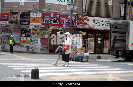 Japanese couple wearing masks, walking in Shinjuku, Tokyo, Japan, Asia ...