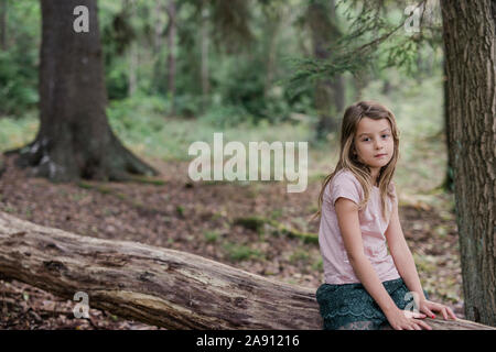 girl sitting on a tree trunk Stock Photo - Alamy