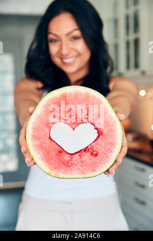 Woman in kitchen holding watermelon Stock Photo - Alamy