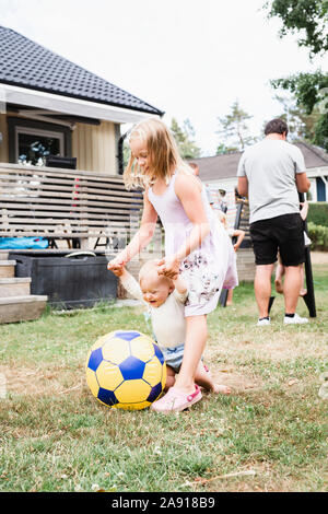 siblings playing soccer in the garden Stock Photo - Alamy
