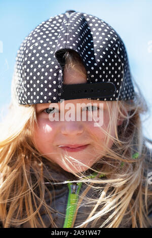 smiling girl in cap with long hairs over white Stock Photo - Alamy