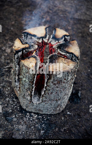 Vertical image of embers of a burning log creating a fiery background ...