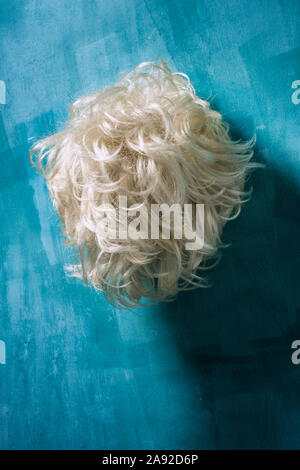 Blonde wig hanging on a wall Stock Photo - Alamy