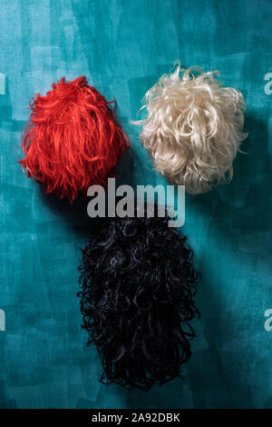 Three wigs hanging on a wall Stock Photo - Alamy