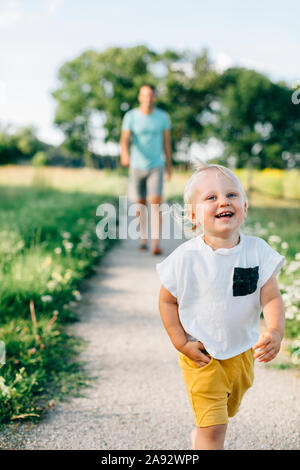 Positive father and toddler child walking on crosswalk outdoors in ...