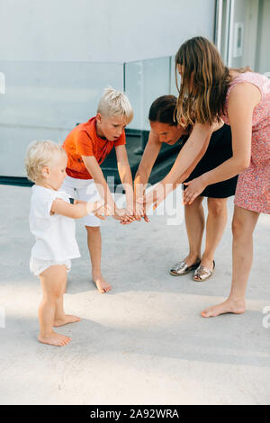 Four people stacking hands together in sign of teamwork and unity ...