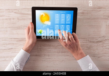 Man hand checking weekly weather forecast on tablet Stock Photo - Alamy