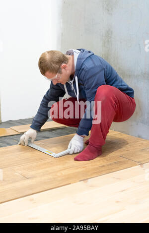 man puts the concrete tiles on the path Stock Photo - Alamy