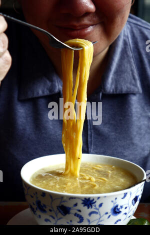 People eat the noodles with fork on wooden table background Stock Photo ...