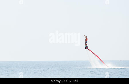 A man engaged in flyboarding on the ocean Stock Photo - Alamy