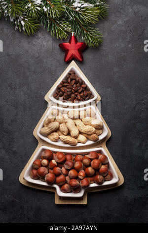 Christmas greeting card with various nuts in fir tree shaped box and ...