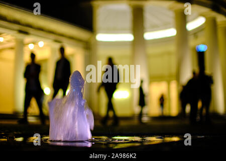 Illuminated water in front of "Elisenbrunnen" fountain in the heart of ...