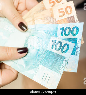 Fifty real note with hand holding, brasilian money, dark background and ...