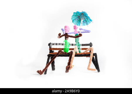 Pipe cleaner figures sitting on a green glass vase Stock Photo - Alamy