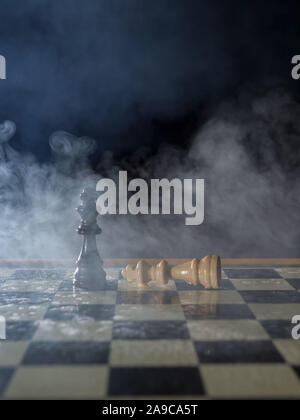 Chessboard with figures on dark background Stock Photo - Alamy