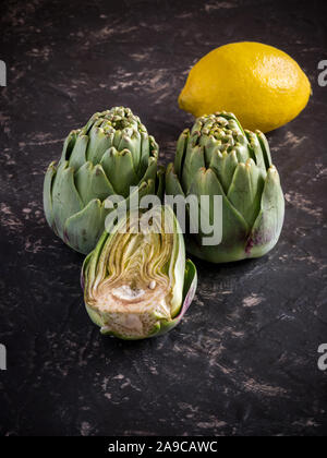 Fresh artichokes on dark gray stone background Stock Photo - Alamy