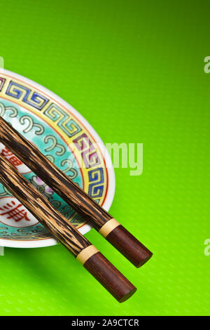 Asian dishes and sticks on green background Stock Photo - Alamy