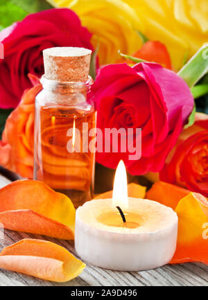 Wellness rose oil and candle Stock Photo - Alamy