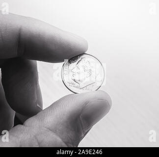Photograph of a man holding an american dollar dime Stock Photo - Alamy
