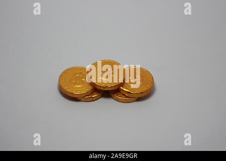 chocolate shaped like coins in gold foil sheet isolated on white ...