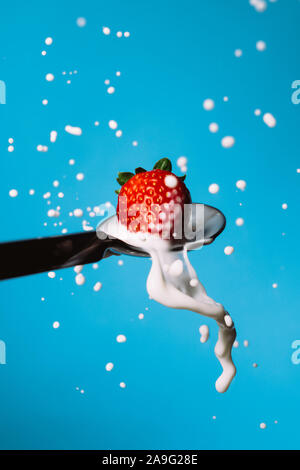 Color fresh sweet milk drops into another color of milk in cup with ...