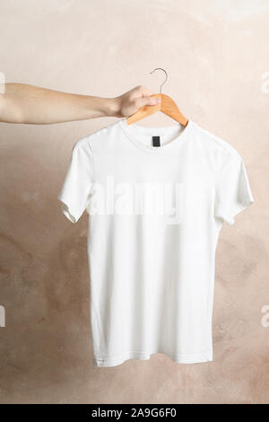 Male hand holds hanger with blank white t-shirt Stock Photo - Alamy