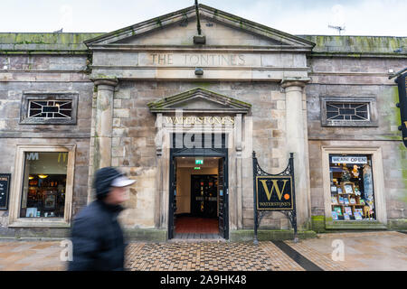 People walk past a restaurant as water is sprayed to cool the area on a ...