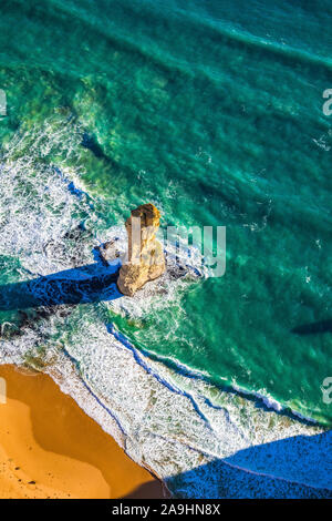 An aerial view of natural rock formations and a turquoise shiny sea of ...