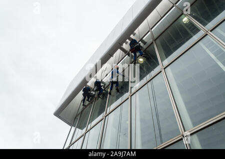 Windows washers cleaning glass facade of a high rise building Stock ...