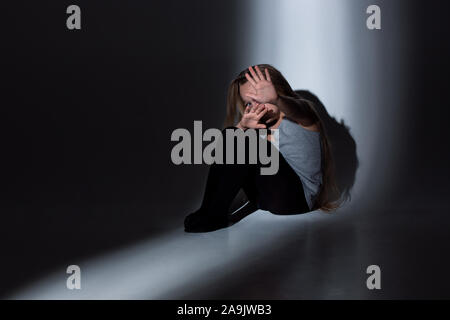 Sad and frightened little girl with bloodshot, bruised eyes crying ...