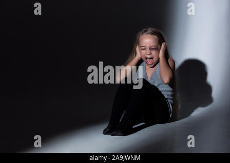 Sad and frightened little girl with bloodshot, bruised eyes crying ...