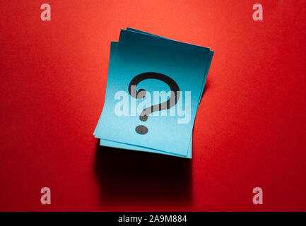 Pile of stacked question marks printed on white paper viewed from ...
