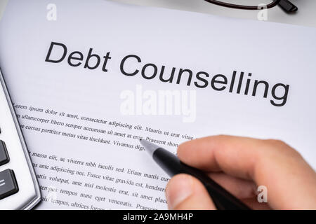 Close-up Of A Person Signing Debt Counseling Form On Office Desk Stock ...