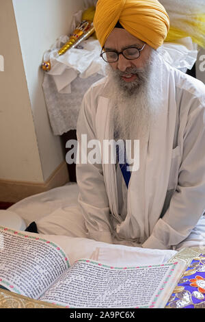 A Sikh granthi reading from the Guru Granth Sahib in a gurdwara Stock ...