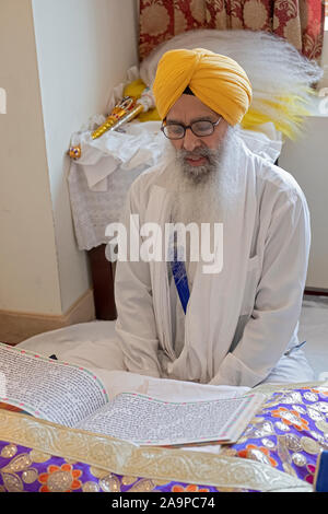 A Sikh granthi reading from the Guru Granth Sahib in a gurdwara Stock ...