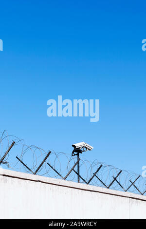 highly protected prison wall with barbed wire fence. steel grating ...