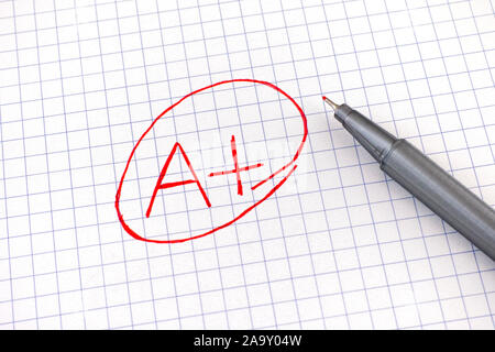 A plus (A+) grade on notebook paper sheet with math operation solved ...