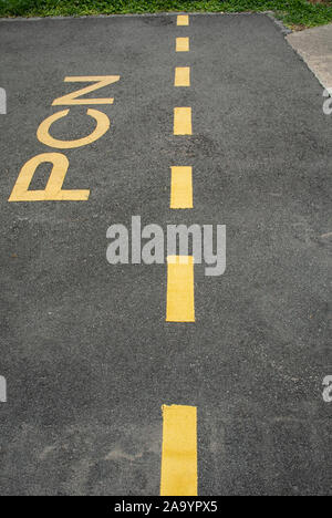 Yellow 'PCN' sign and lines on asphalt road Stock Photo - Alamy