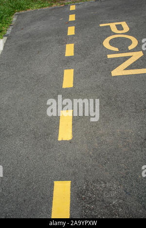 Yellow 'PCN' sign and lines on asphalt road Stock Photo - Alamy