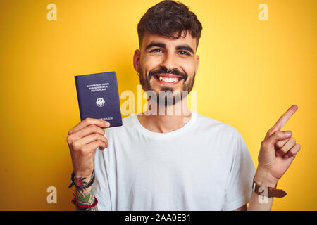 Young man with tattoo wearing German Germany passport over isolated ...