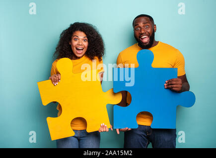 Couple with puzzles in hand over light blue background. Concept of ...