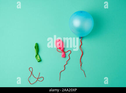 blue inflated and deflated rubber balls and red rope on a green ...