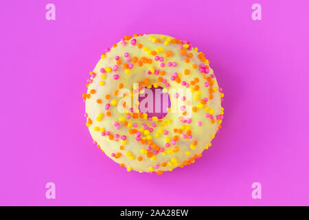 Pink donut with multicolored sprinkles on yellow background. Creative ...