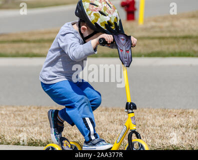 Little boy riding three wheeled scooter outdoors Stock Photo - Alamy