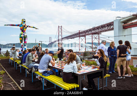 Rooftop bar with statue at LX Factory, under the Ponte 25 de Abril ...