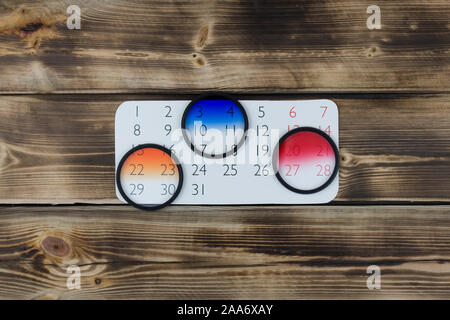 Calendar sheet and camera lens filter on wooden Stock Photo - Alamy