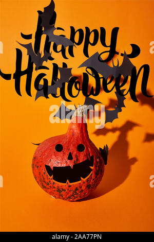 spooky pumpkin and paper bats with shadow on orange background ...