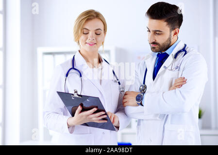 Two doctors discussing a patient X Ray on the screen showing a broken ...