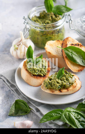 Tasty toasts with pesto sauce and garlic on grunge background Stock ...