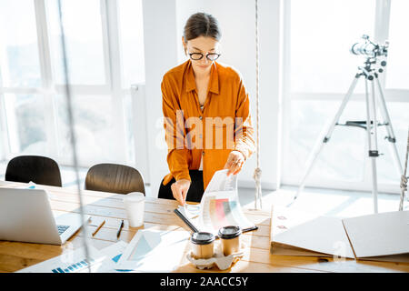 Casually Dressed Young Businesswoman Working On Laptop At Desk In ...